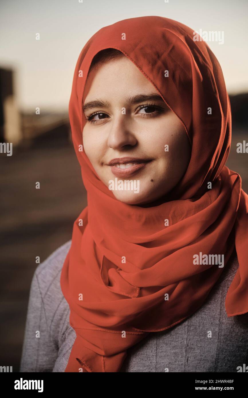 Smiling young woman wearing red hijab Stock Photo - Alamy
