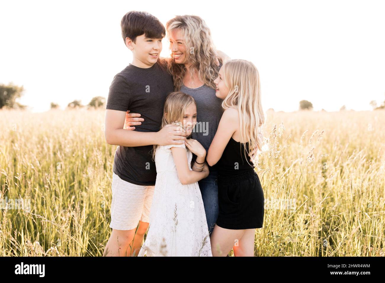 Mother embracing children in farm Stock Photo - Alamy