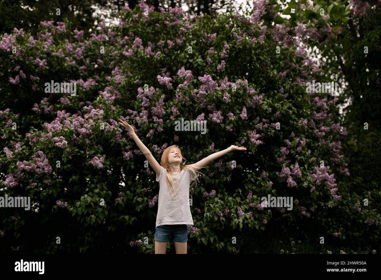 Girl with arms raised in nature Stock Photo - Alamy