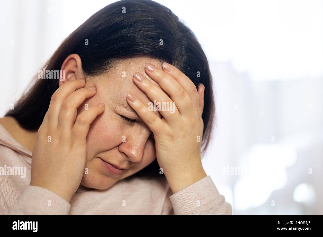 Young woman suffering of strong ear ache and tinnitus after COVID-19 ...