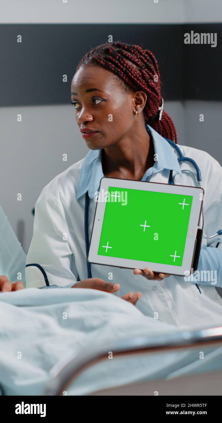 Physician holding digital tablet with horizontal green screen, showing ...
