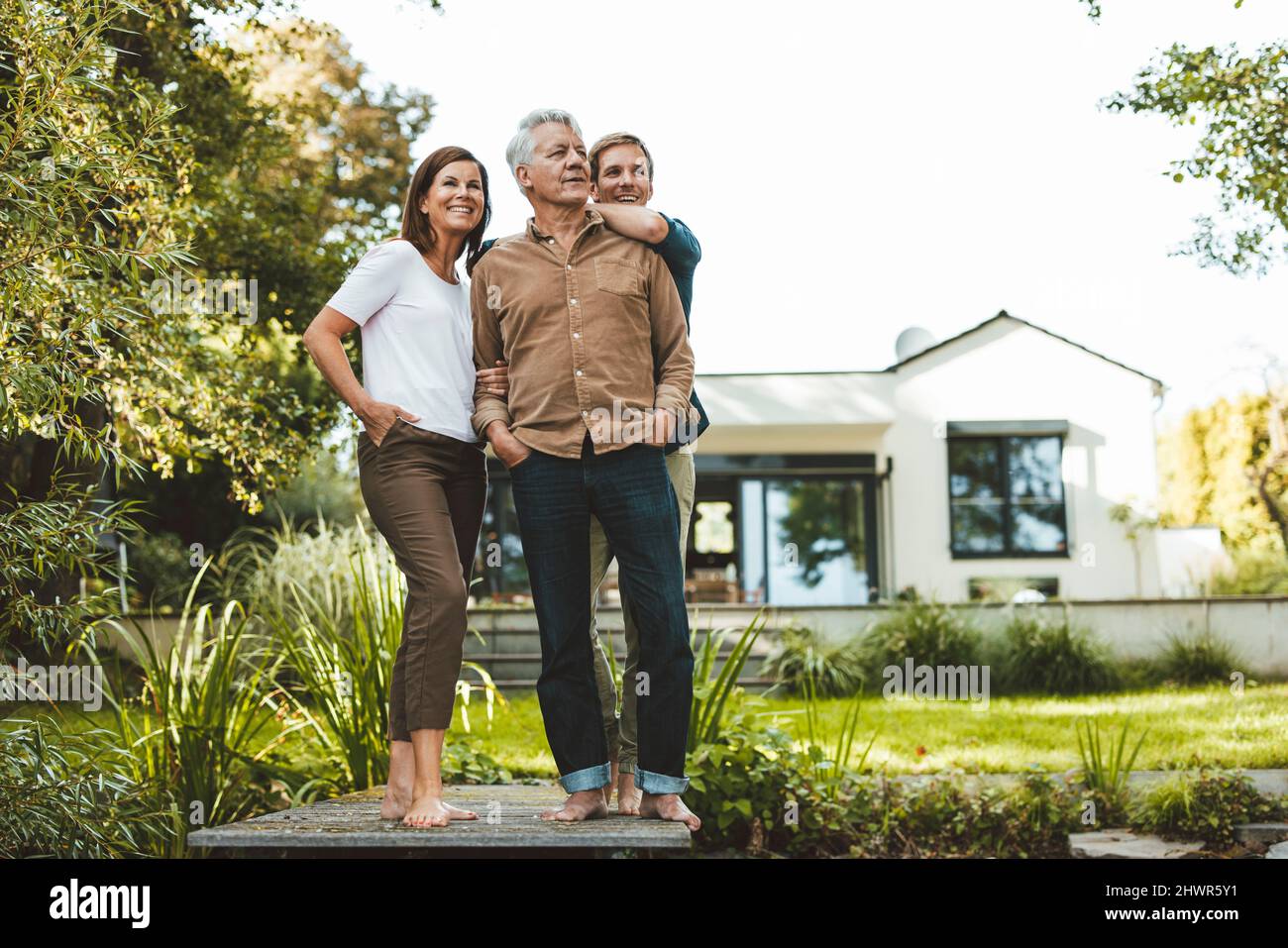 Happy family standing together in garden Stock Photo - Alamy