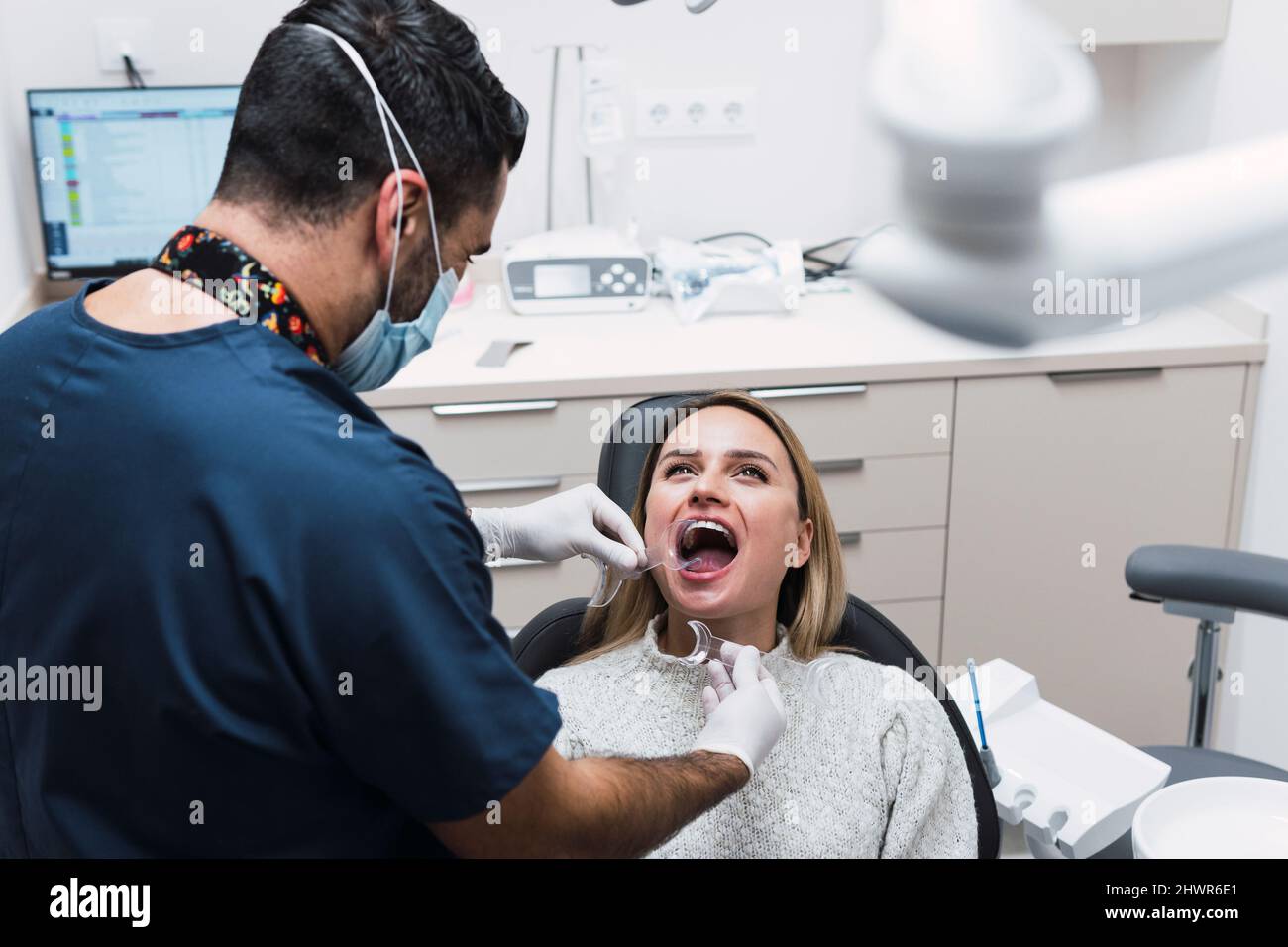 Dentist checking patient's teeth in medical room at clinic Stock Photo ...