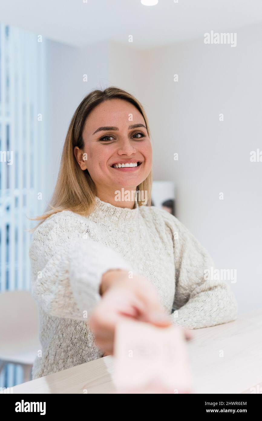 Happy young woman at reception desk in clinic Stock Photo - Alamy