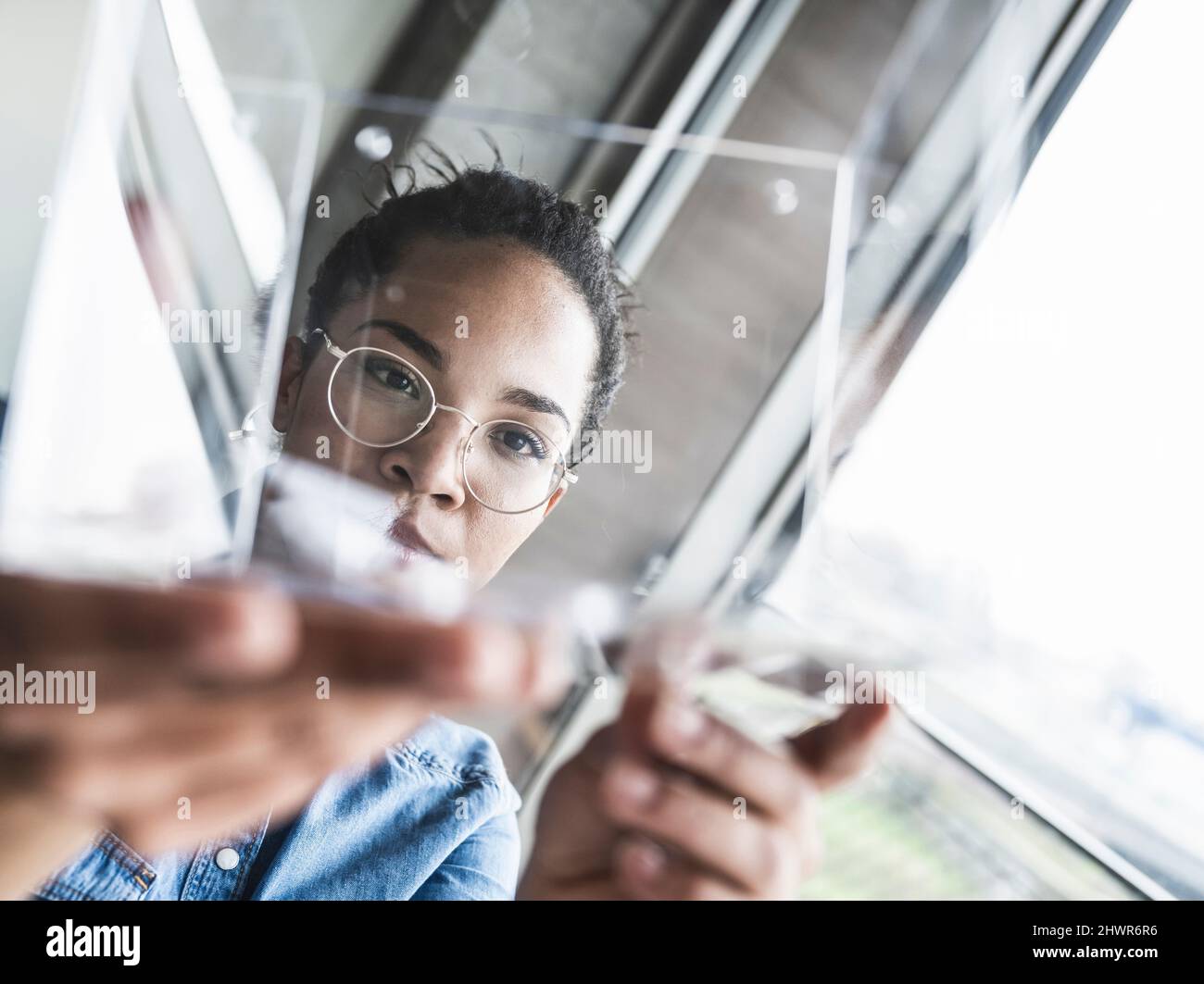 Businesswoman analyzing glass object at work place Stock Photo - Alamy