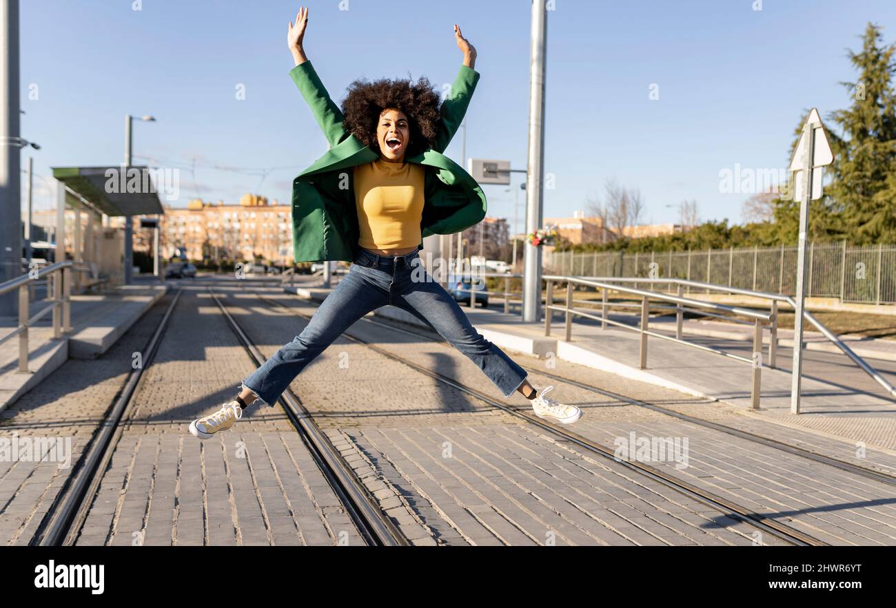 Cheerful businesswoman jumping on tramway Stock Photo - Alamy