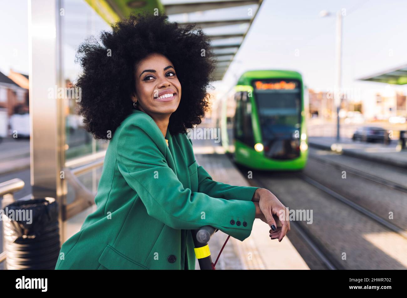 Smiling commuter waiting for tram at station Stock Photo - Alamy