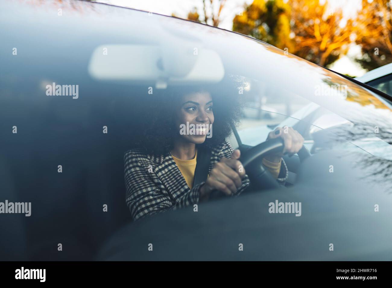 Happy woman driving car seen through windshield Stock Photo - Alamy