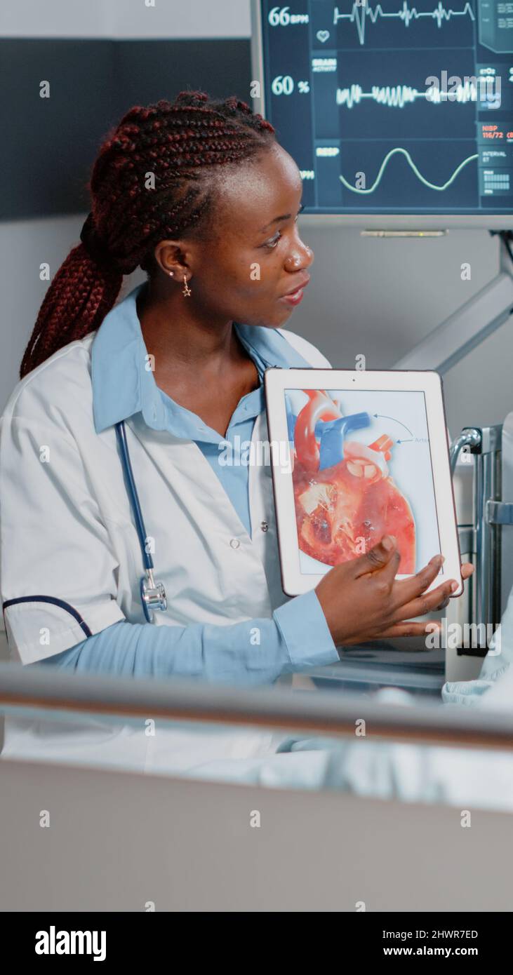 Medic pointing at tablet with cardiology image on display, explaining ...