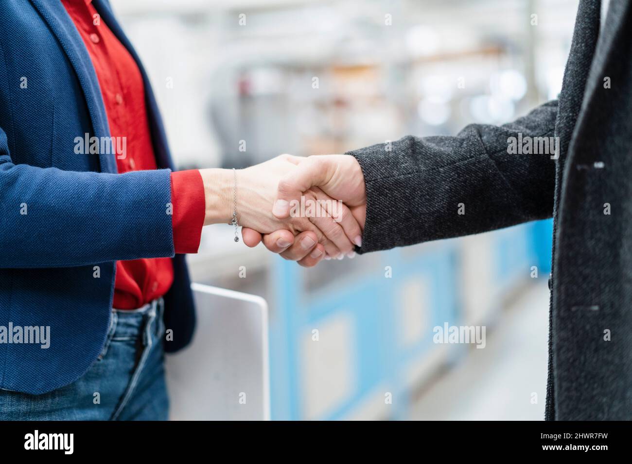 Businessman and businesswoman shaking hands at factory Stock Photo - Alamy