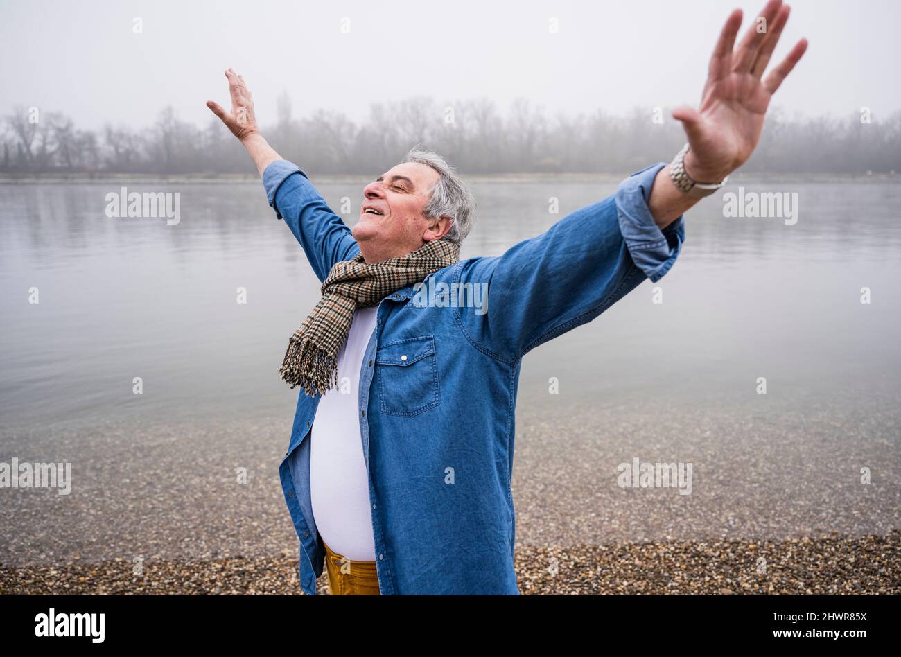 Senior man standing with arms outstretched at beach Stock Photo - Alamy