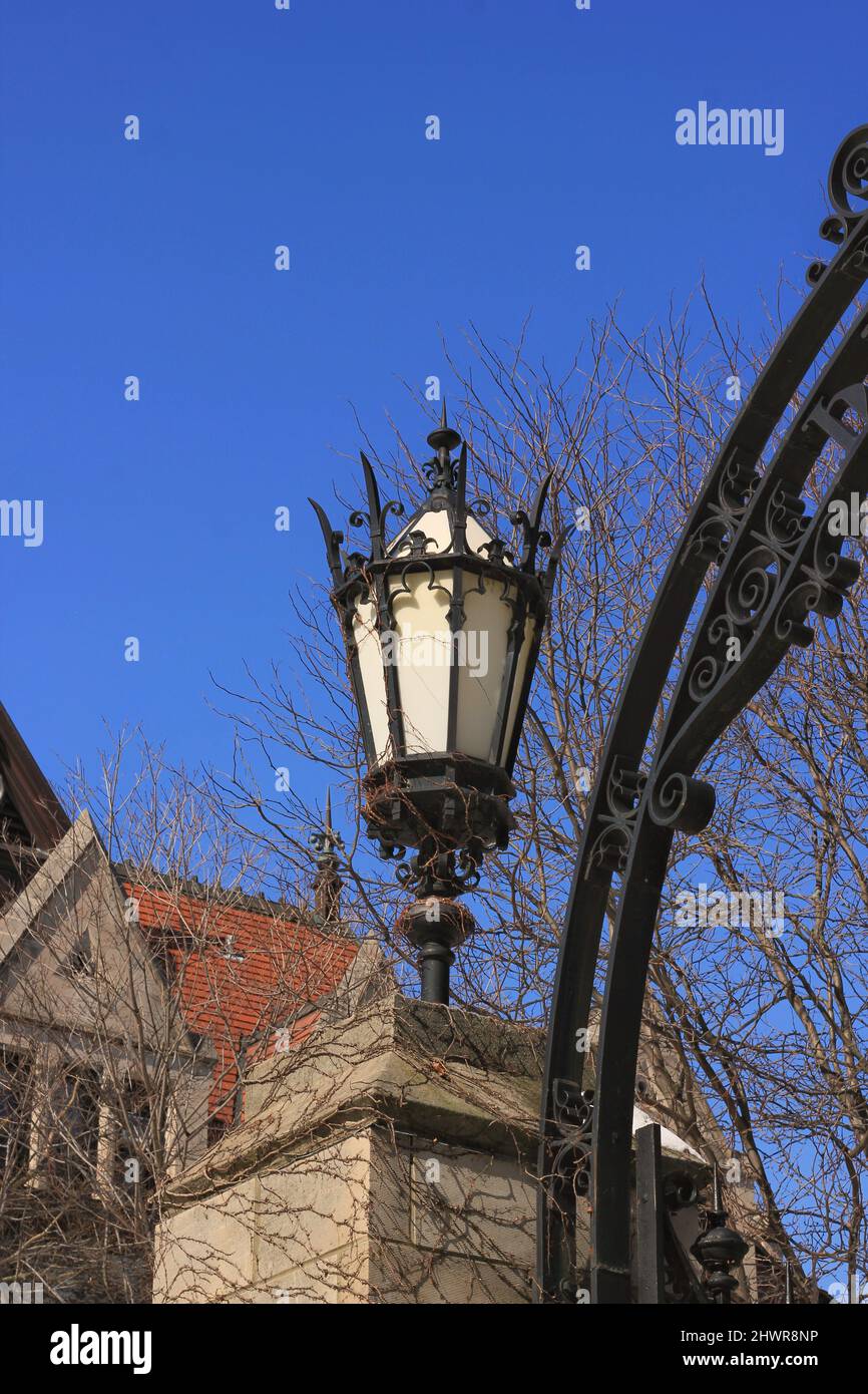 Old Gothic medieval cast iron street lamp standing in the courtyard ...