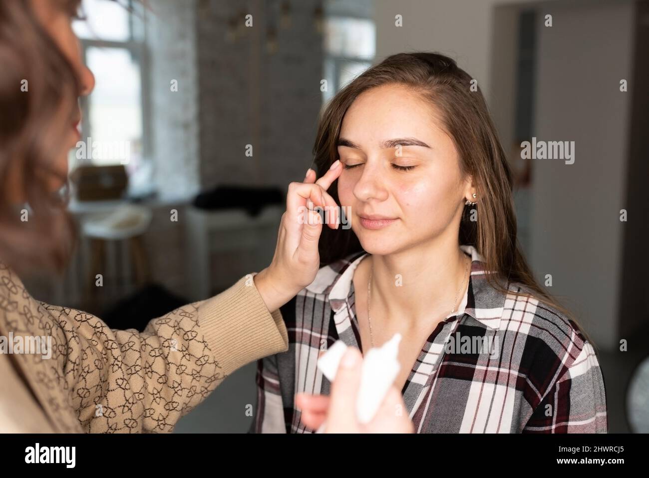 Make-up artist applies make-up base on girl's face. High quality photo ...