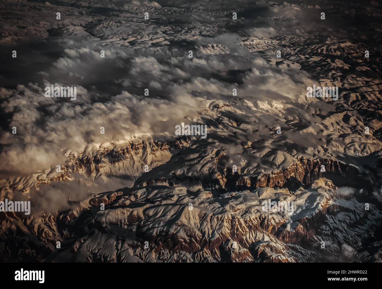 Aerial view from the plane of hills snow and mountains landscape with ...