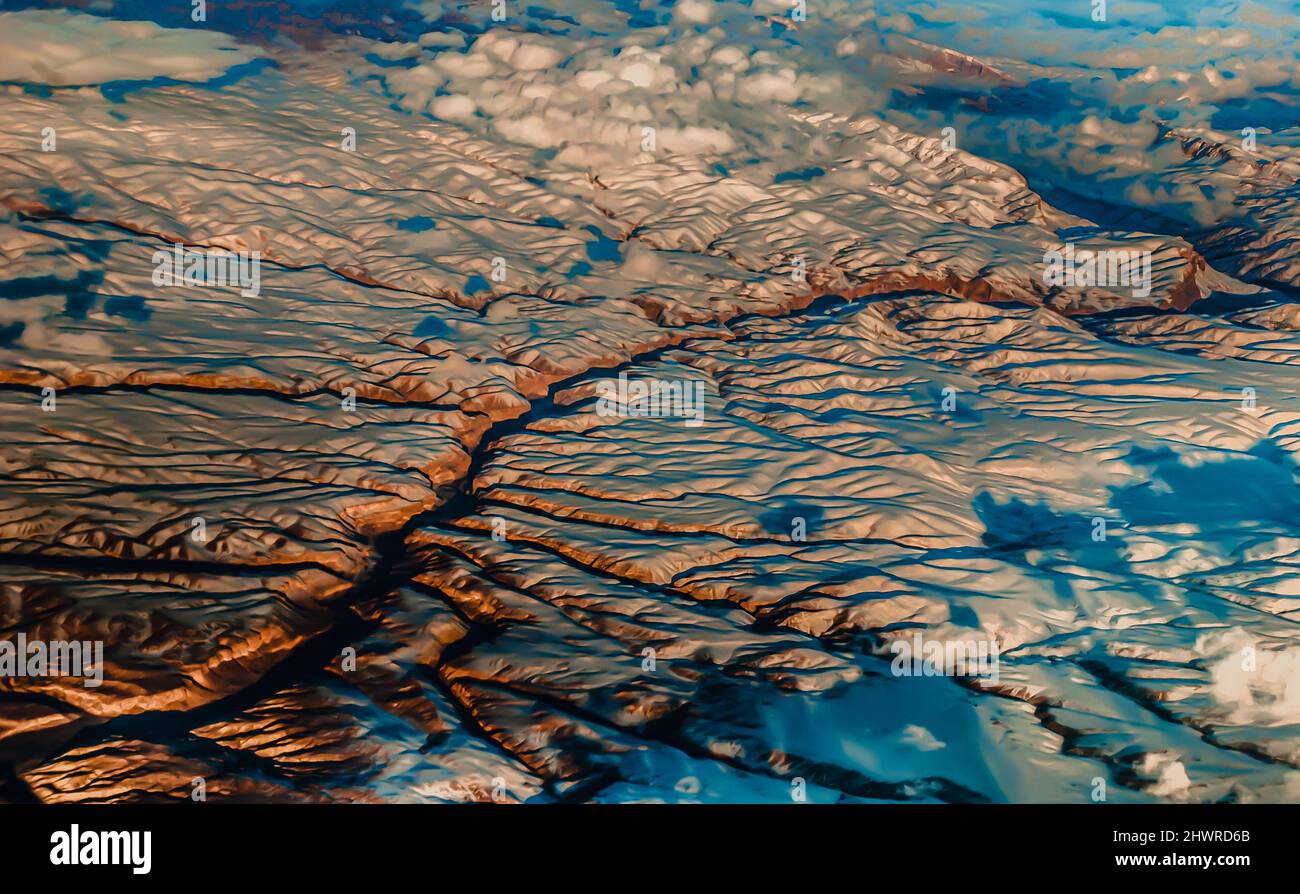 Aerial view from the plane of hills snow and mountains landscape with ...