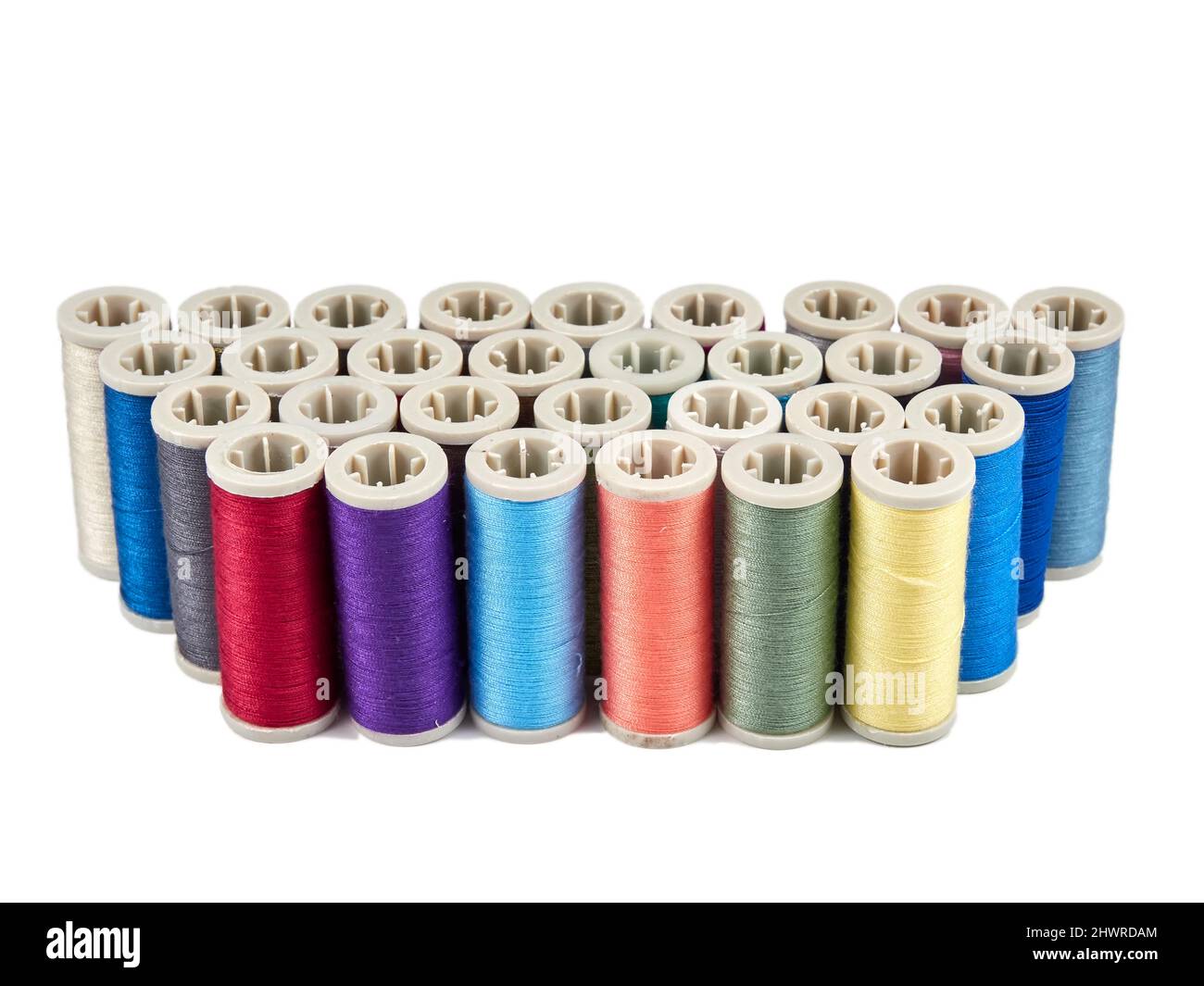 Assortment of spools with colored sewing thread on white background ...
