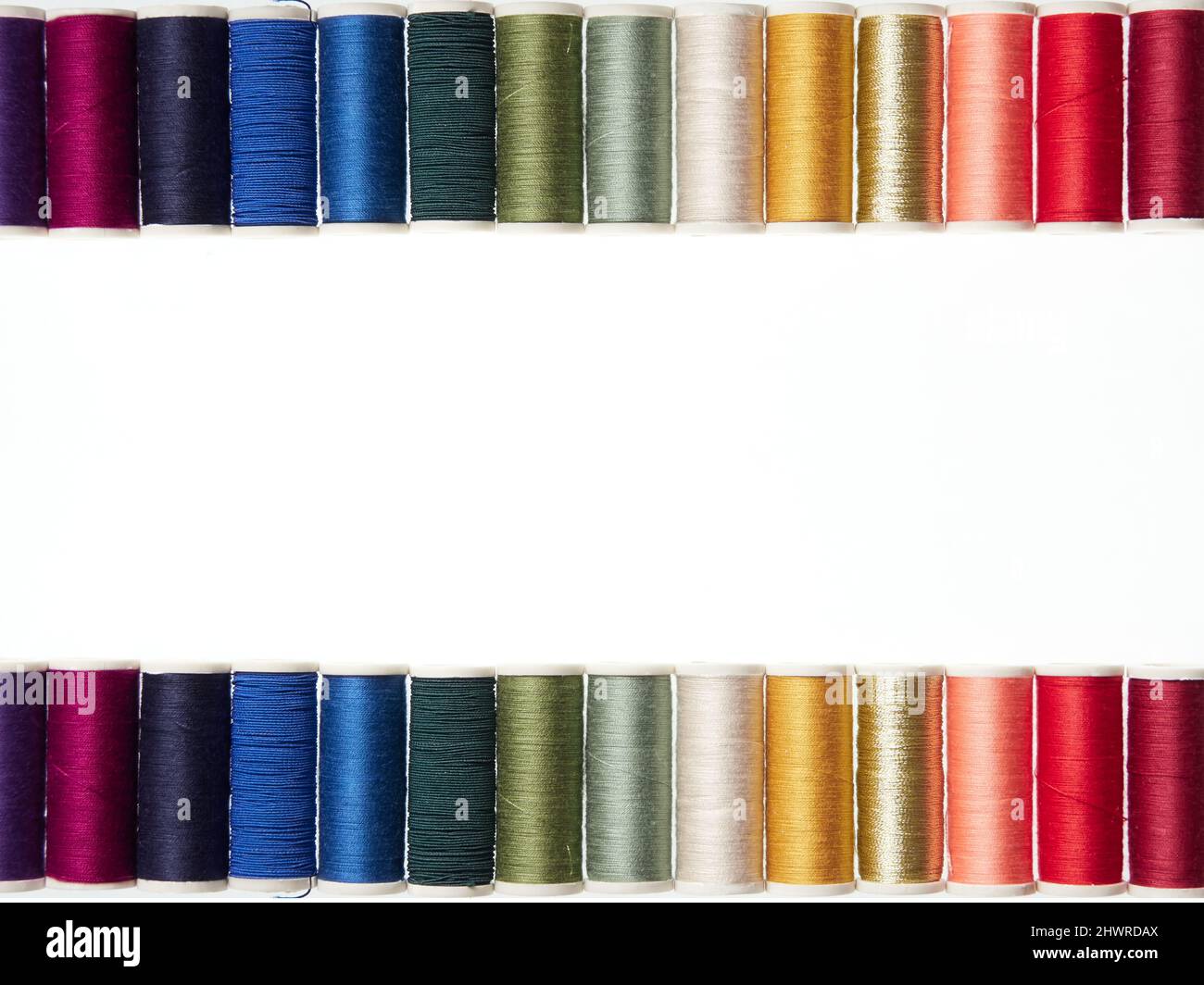 Assortment of spools with colored sewing thread on white background ...