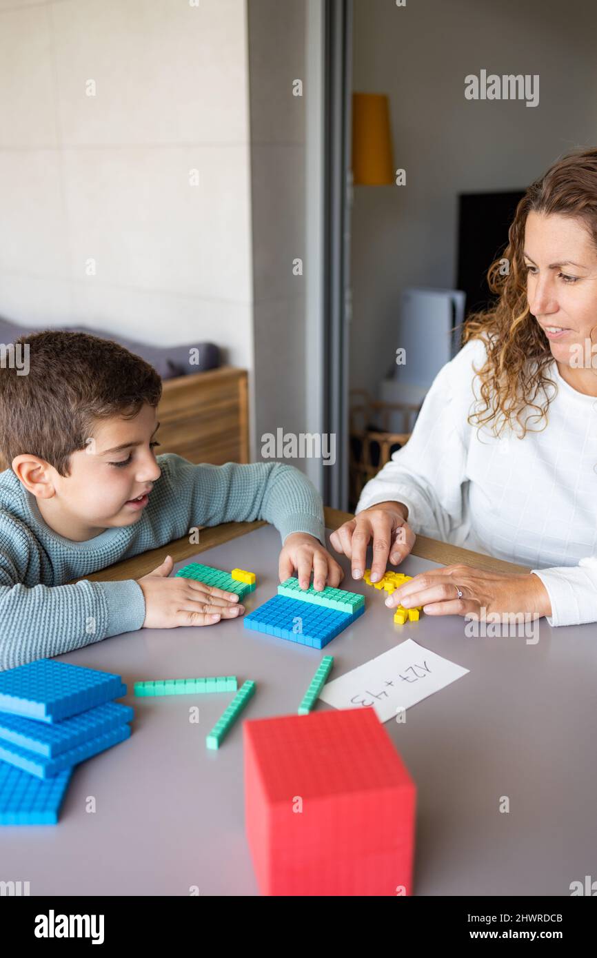 Mother teaching her son math with base 10 method at home Stock Photo ...