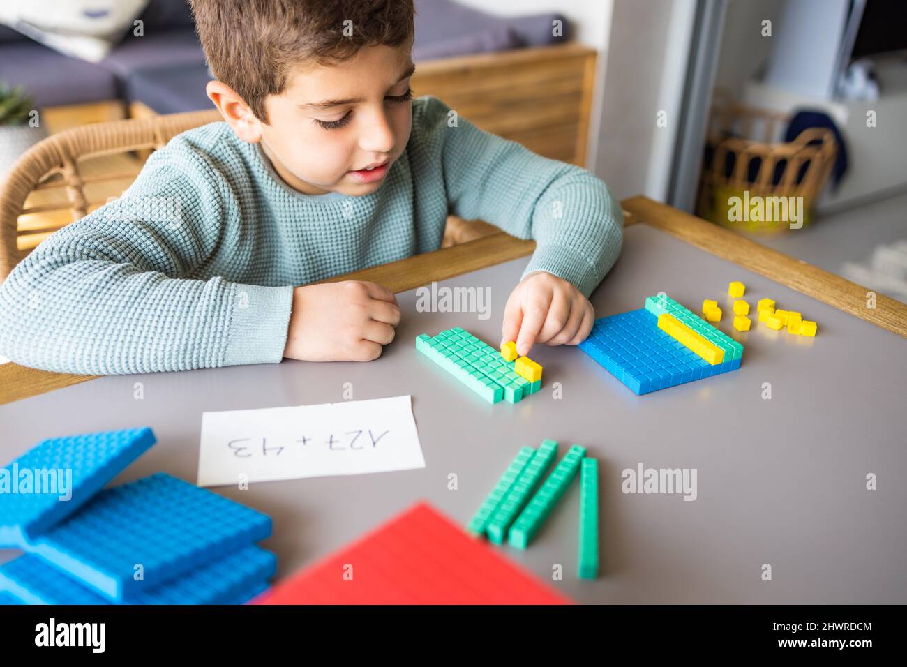 Little boy using the base 10 method to do addition at home Stock Photo ...