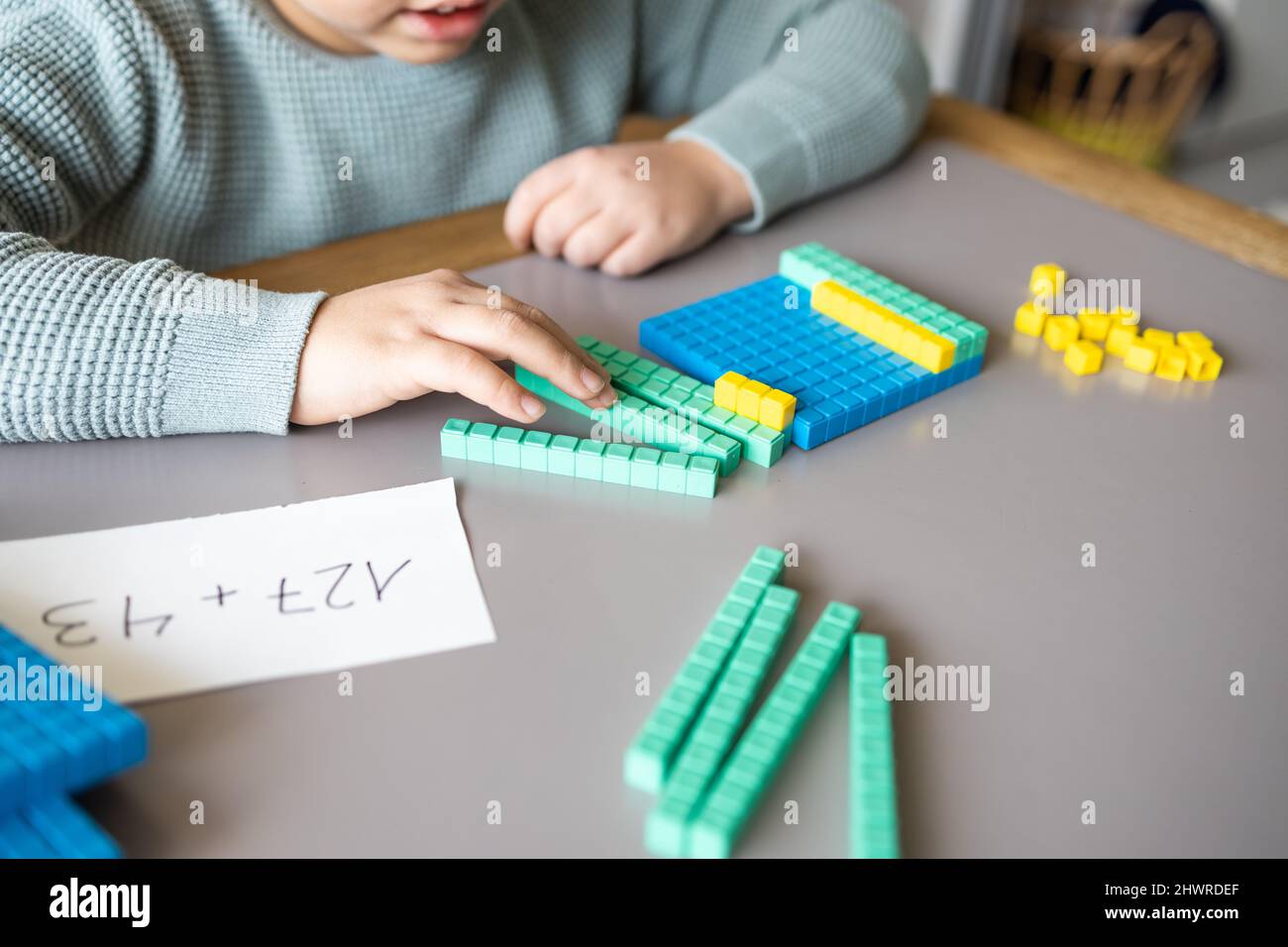 Little boy using the base 10 method to do addition at home Stock Photo ...