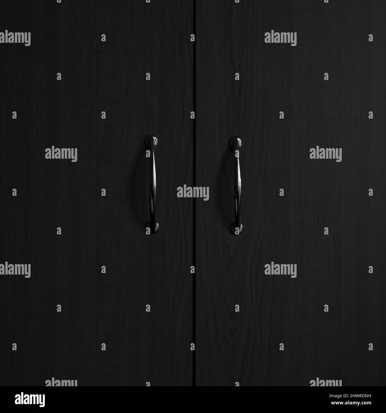 Facade of a closet with shiny metal handles. Frontal black and white ...