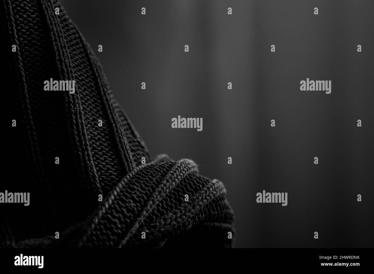 Shoulder of a dark sweater, texture of a knitted wool fabric. Black and ...