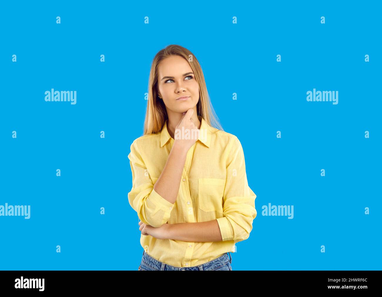 Curious beautiful young girl thinking about something isolated on blue ...