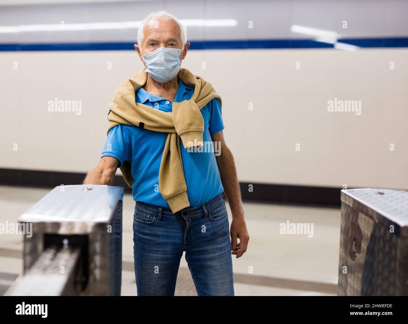 An elderly passenger in a protective mask pays for a subway ride Stock ...