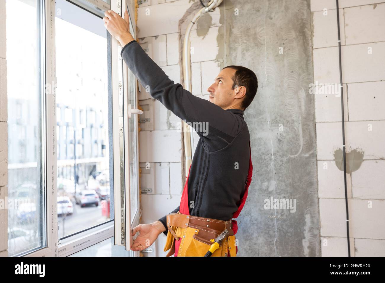 Construction worker repairing windows in house Stock Photo - Alamy