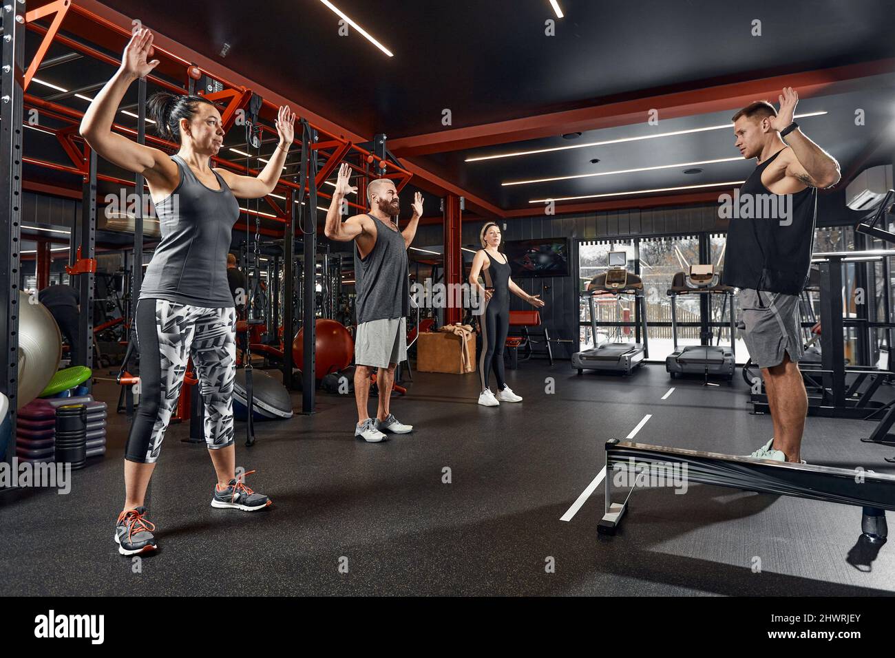 Young and active people on group sports training together do warming up ...