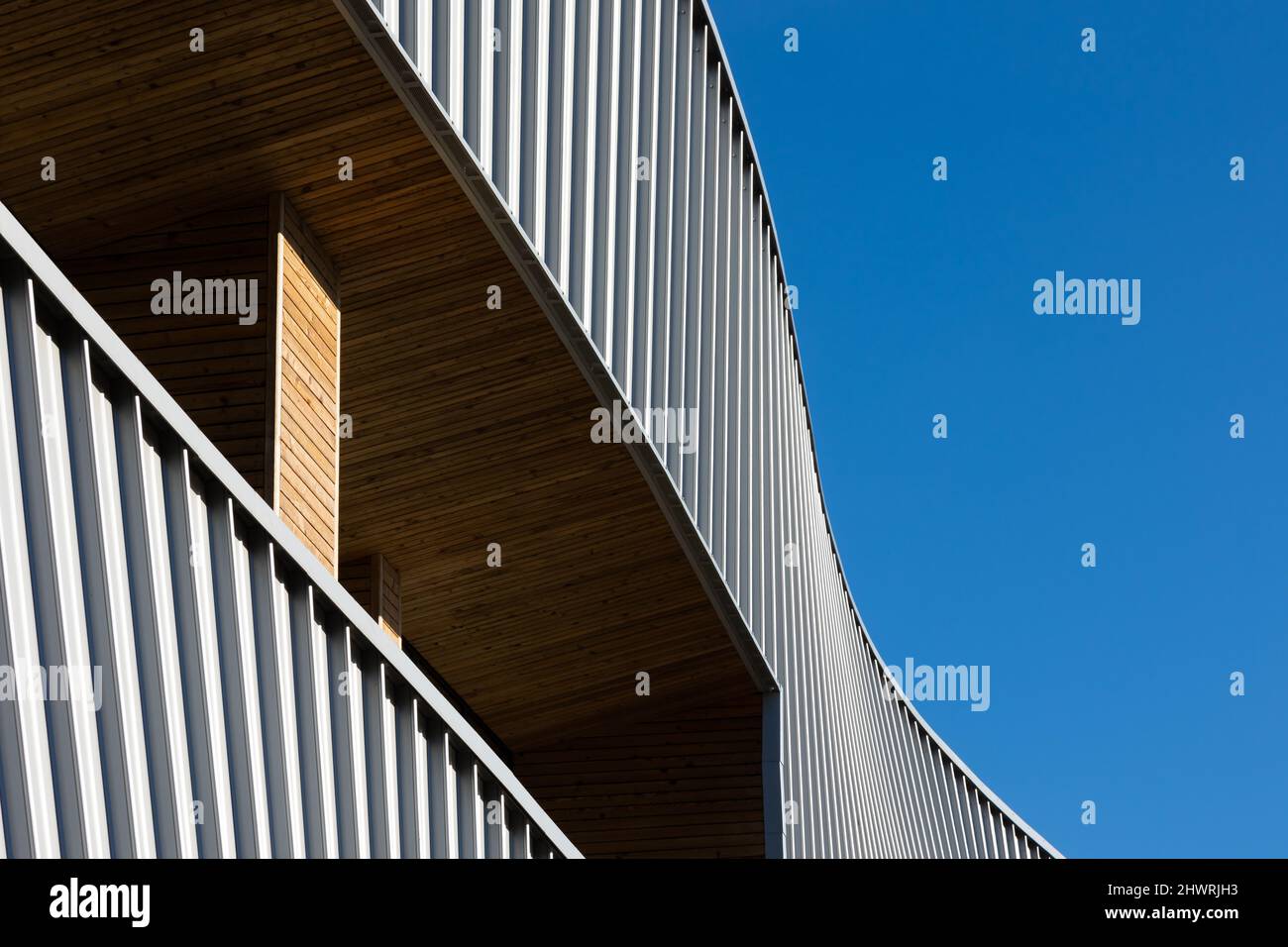 Facade of a modern public building against a blue sky background. Photo ...