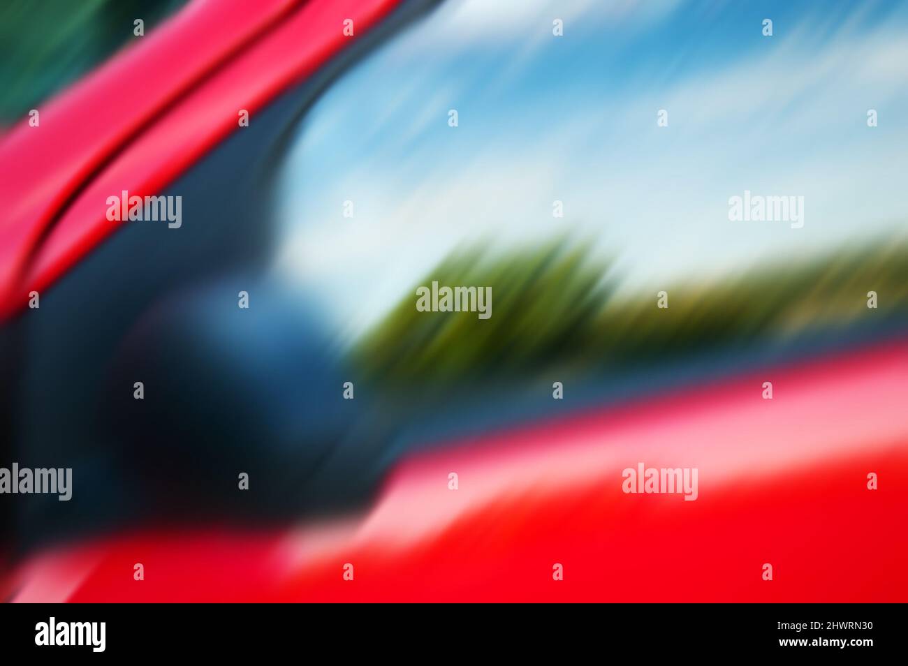 Blurry abstract photo of rural landscape reflected in side window of a ...