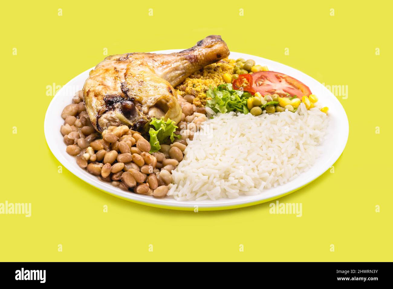 rice and beans dish, large roasted chicken thigh, chopped tomato salad ...