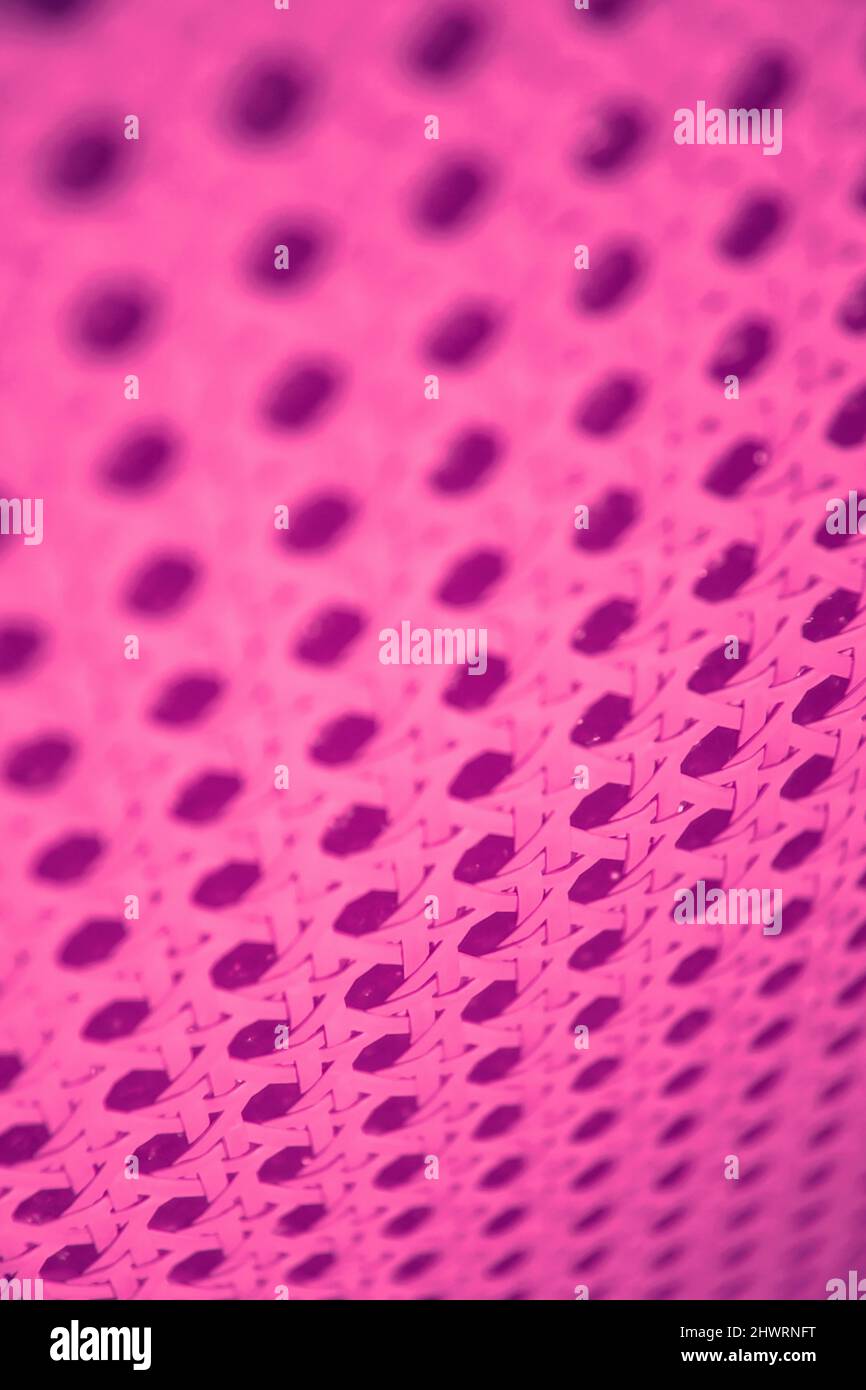 Vertical perforated surface highlighted by pink neon led lights ...
