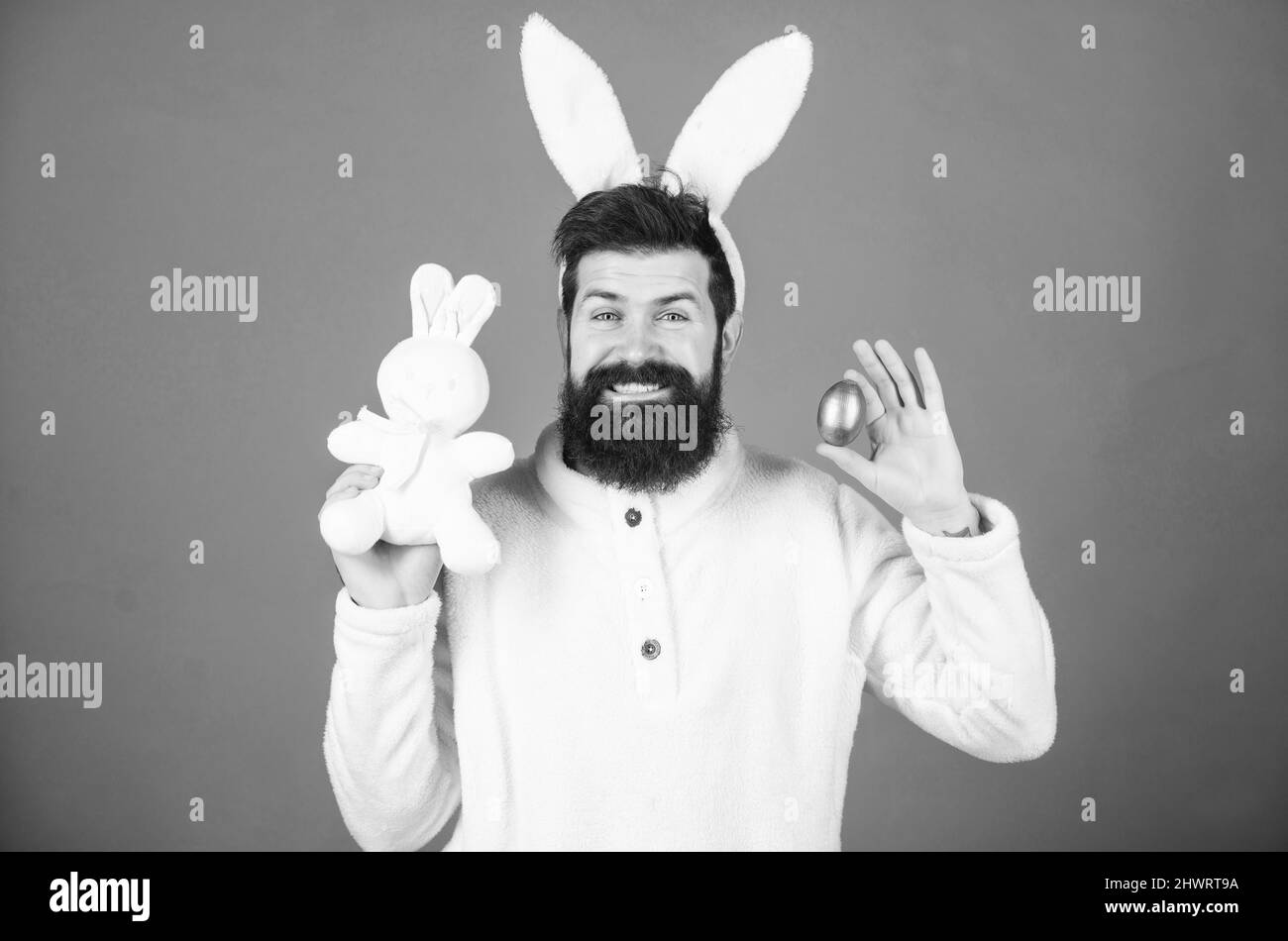 Easter bunny hunt begins. Happy man with rabbit ears holding bunny toy ...