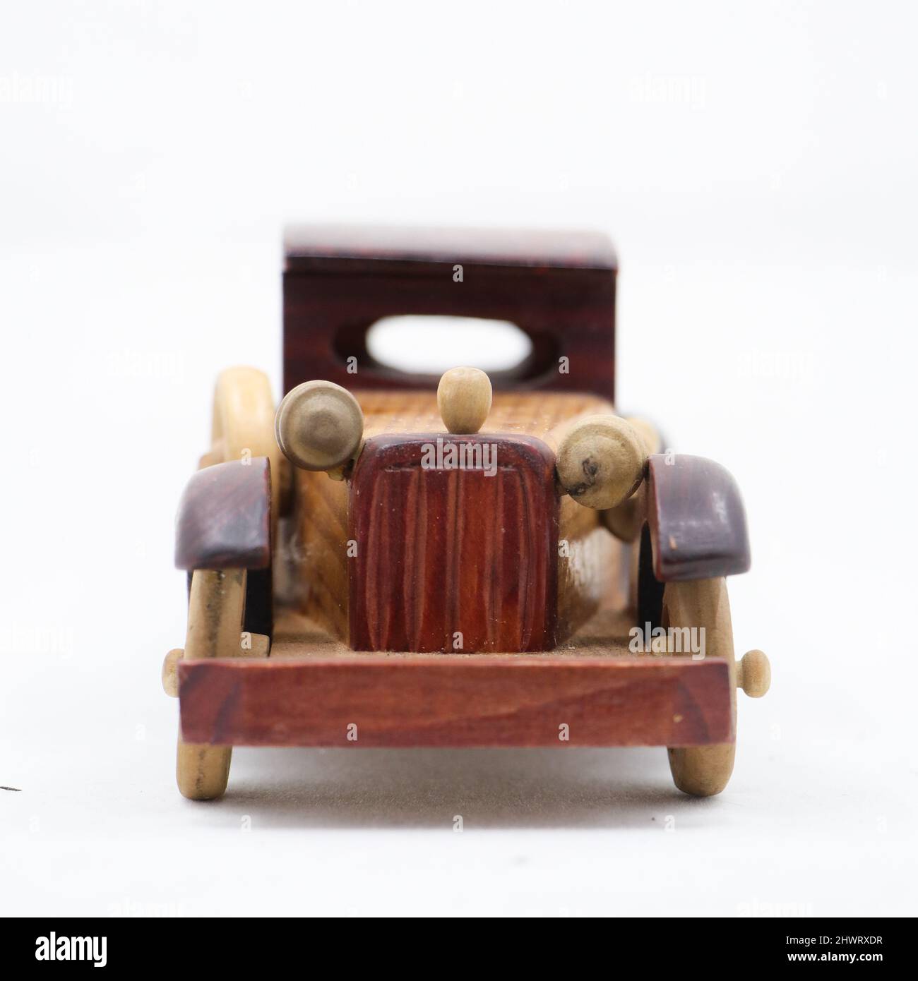 front view of an vintage model brown wooden toy car isolated in a white ...