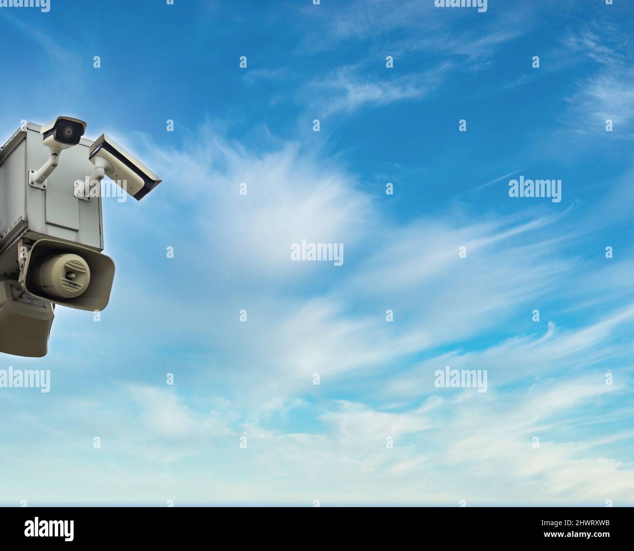 CCTV security surveillance cameras and horn speaker against blue sky ...