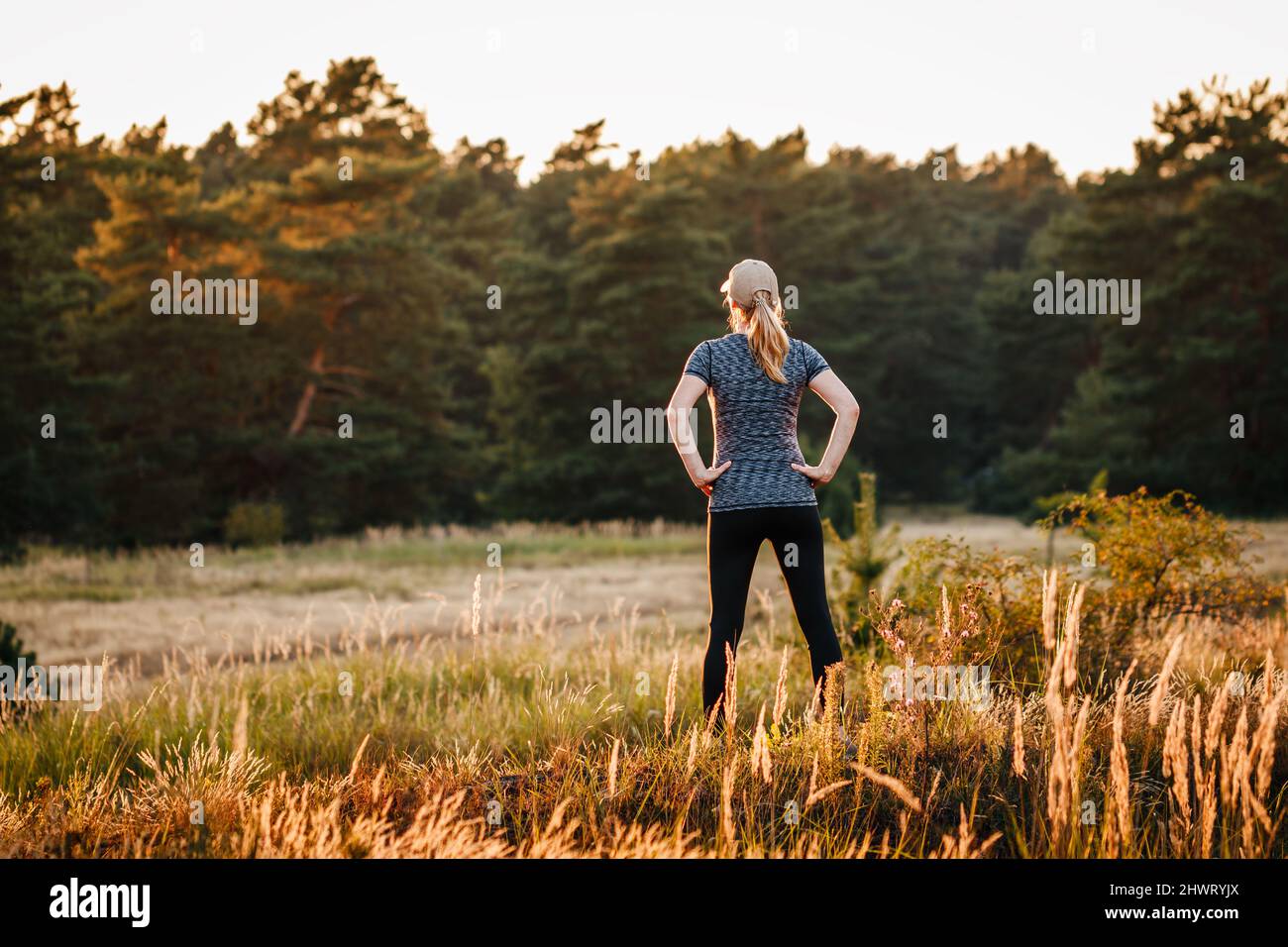 Woman relaxing before running during sunset outdoors. Sportsperson ...