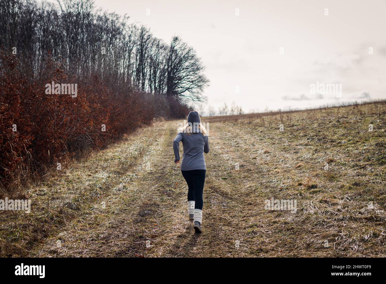 Woman running up to hill. Fitness activity outdoors. Female runner ...