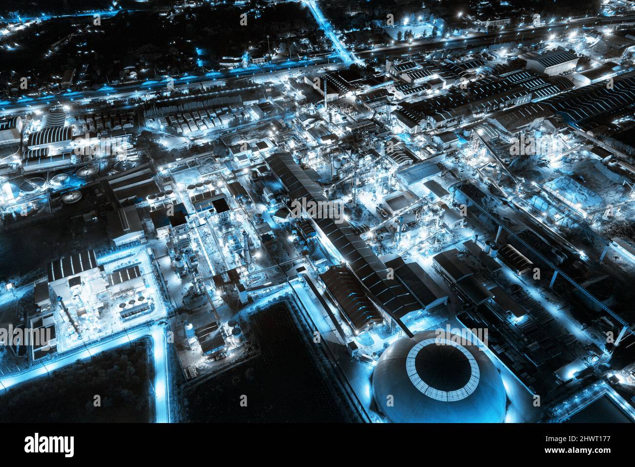Aerial view of blue light industrial factory with chemical refinery and ...