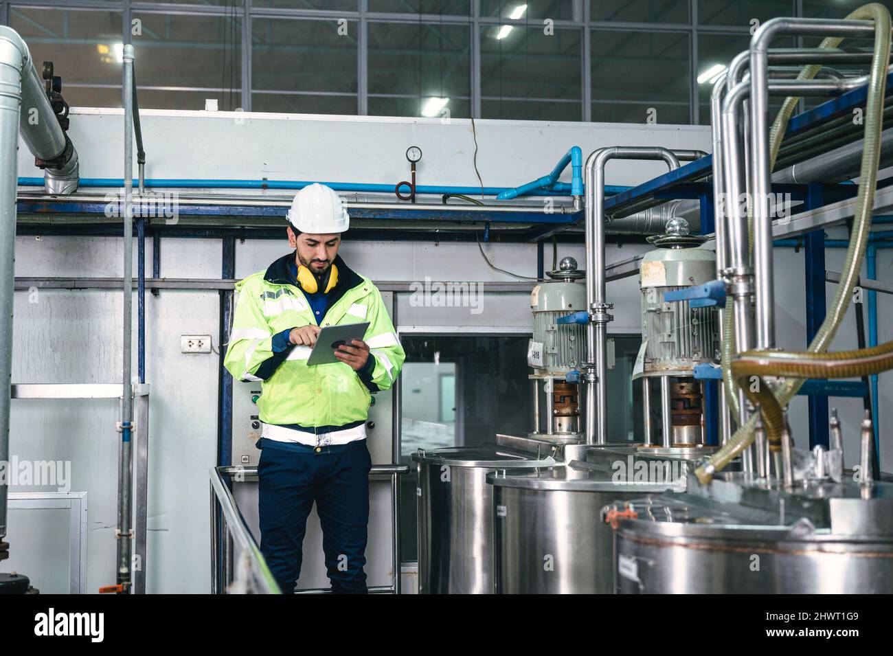 Caucasian technician engineer man in uniform with tablet checking and ...