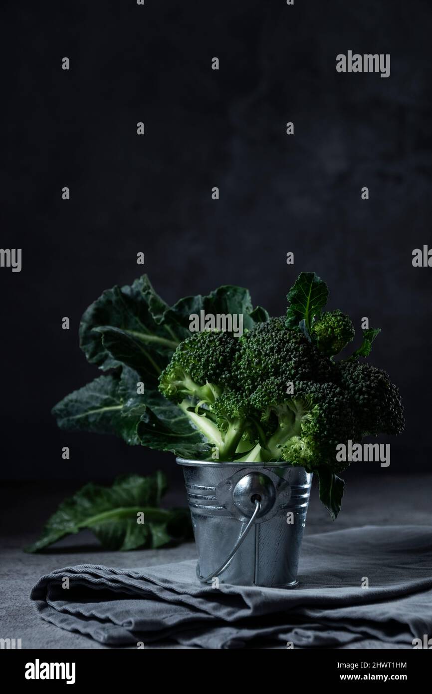 Fresh raw broccoli in bucket. Dark mood, moon light food style. Space ...