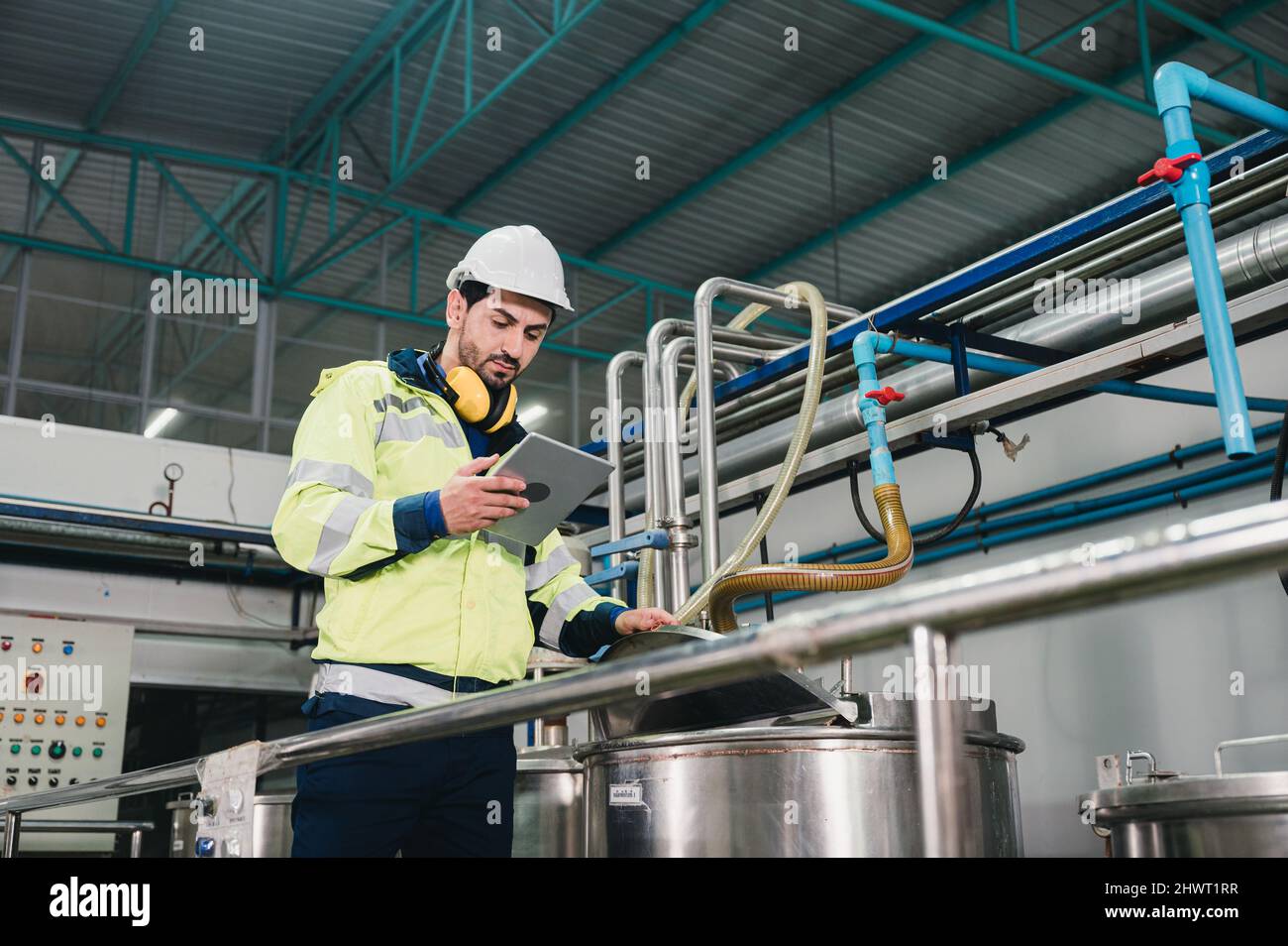Caucasian technician engineer man in uniform with tablet checking and ...