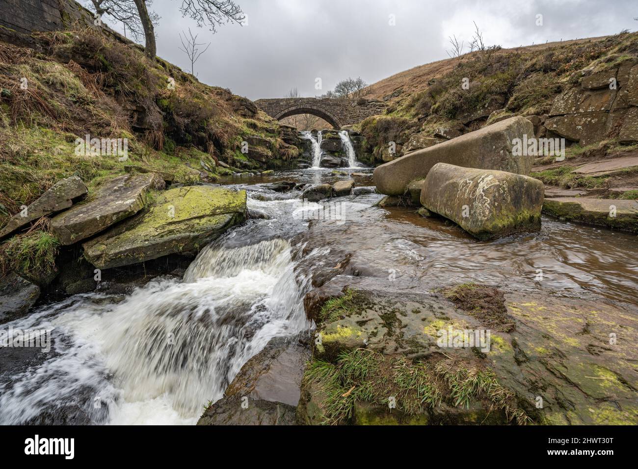Three Shire Heads. An autumnal waterfall and stone packhorse bridge at ...