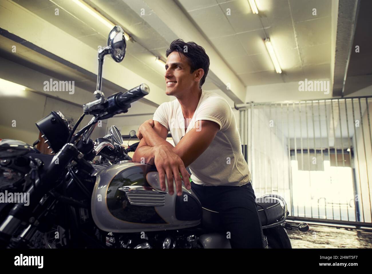 Getting a feel for biking. A handsome young man sitting on his ...