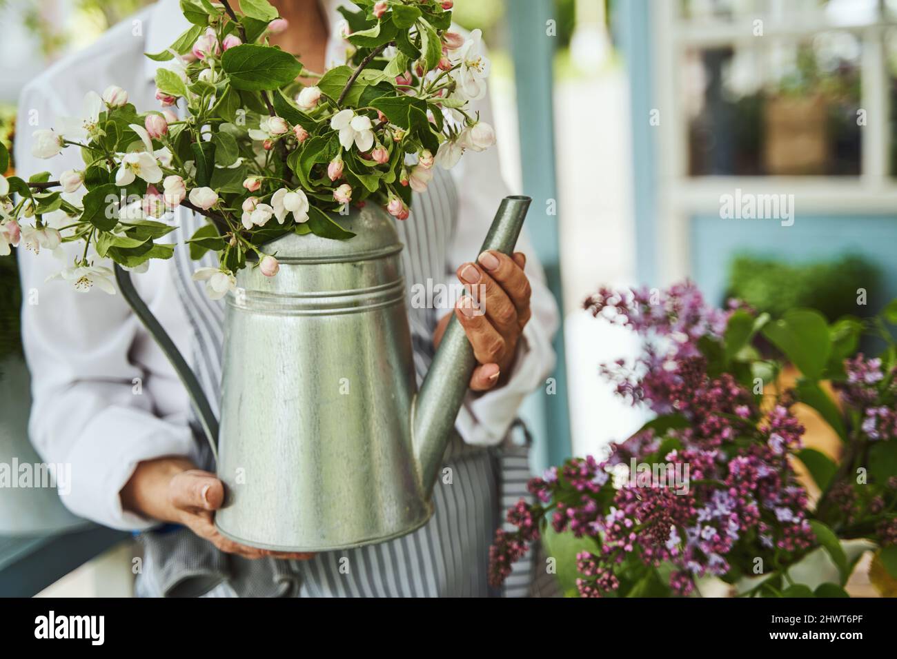 Female taking care of flowers on terrace in village Stock Photo - Alamy