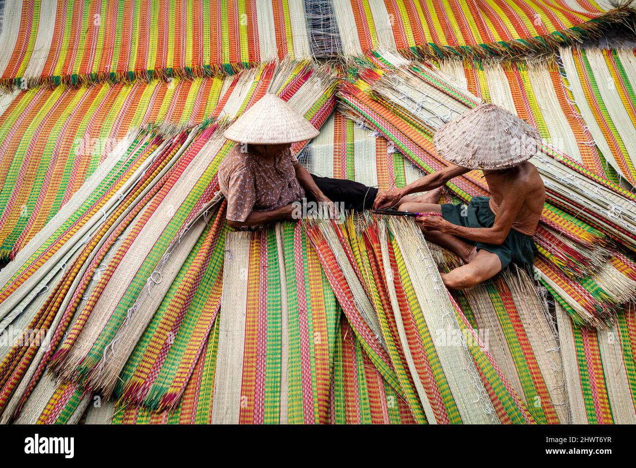 Vietnamese Old Man and Women Making a drying traditional vietnam mats ...
