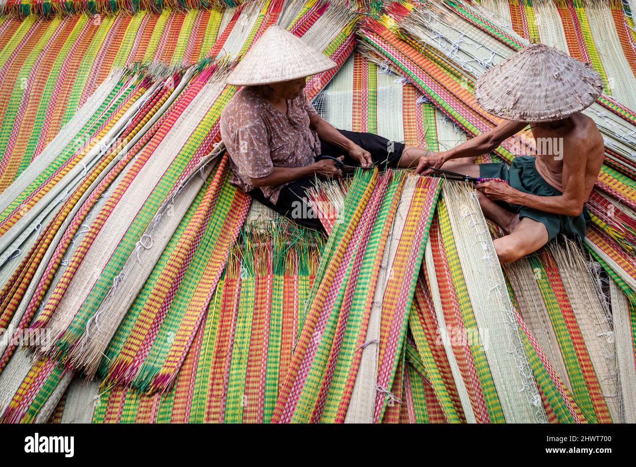 Vietnamese Old Man and Women Making a drying traditional vietnam mats ...