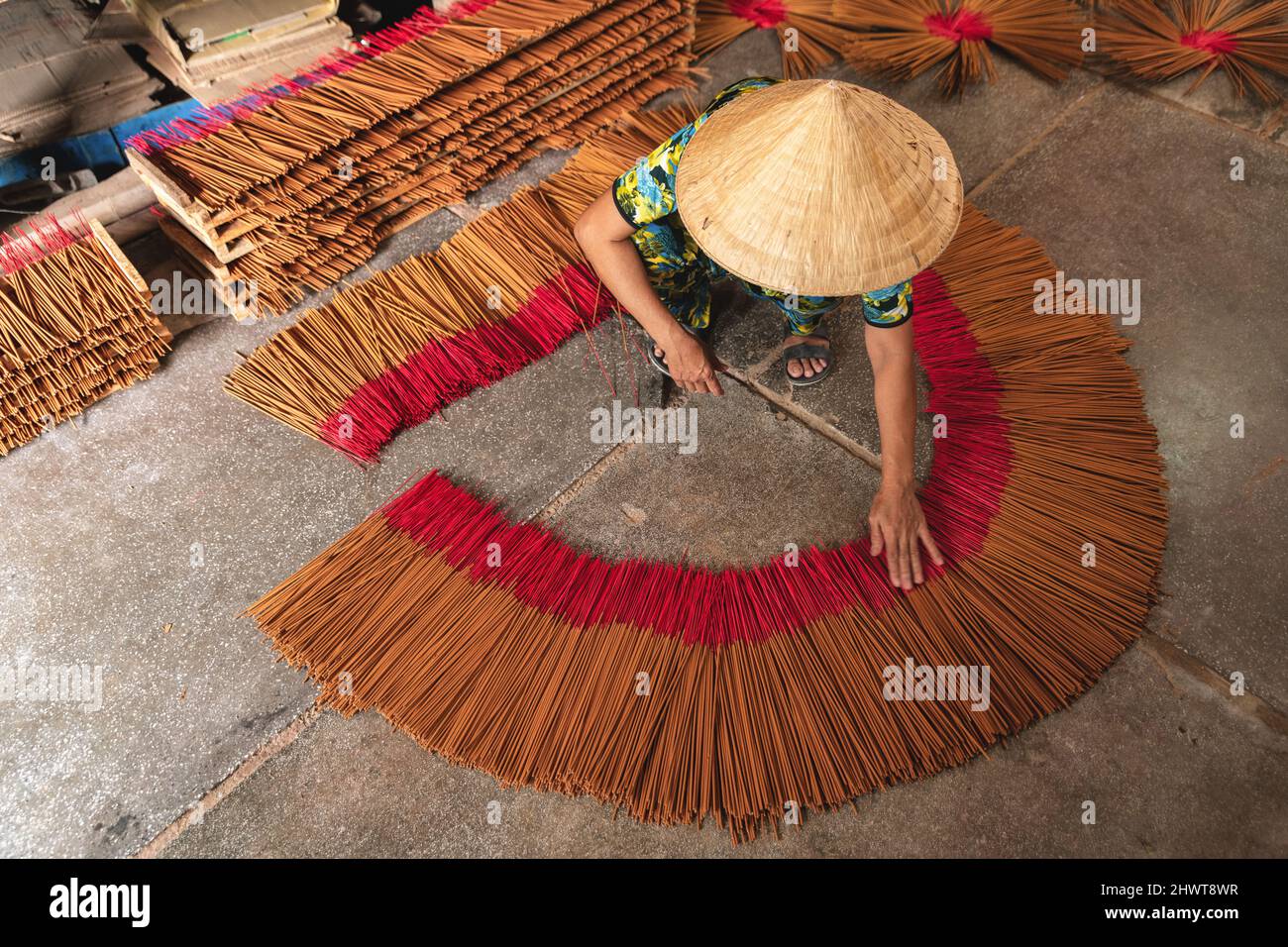 Incense sticks drying outdoor with Vietnamese woman wearing conical hat ...