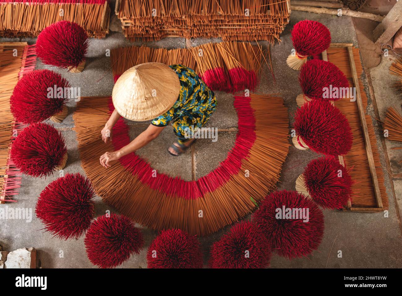 Incense sticks drying outdoor with Vietnamese woman wearing conical hat ...